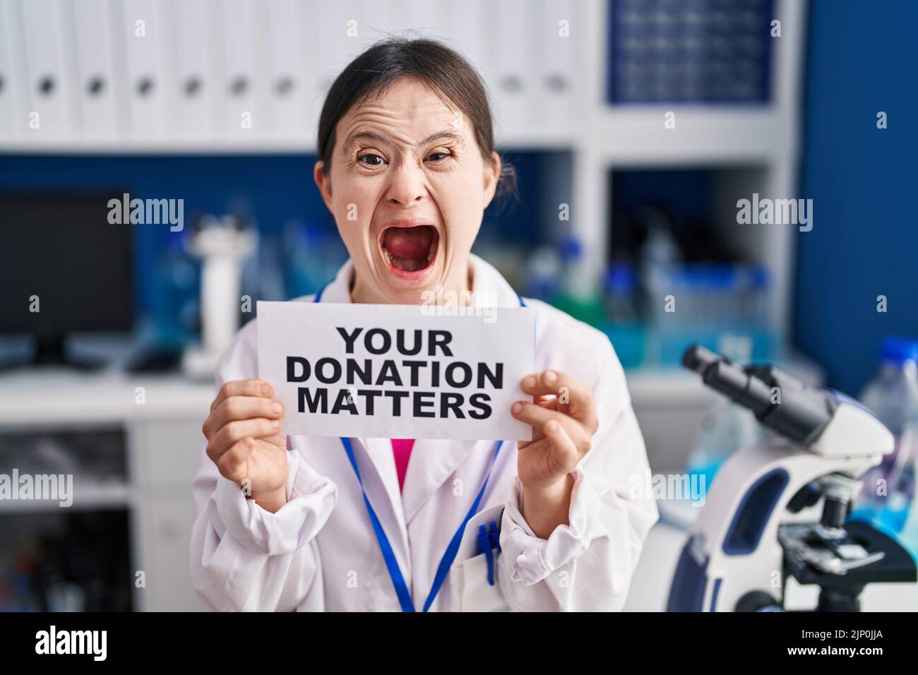 Woman with down syndrome working at scientist laboratory holding your ...