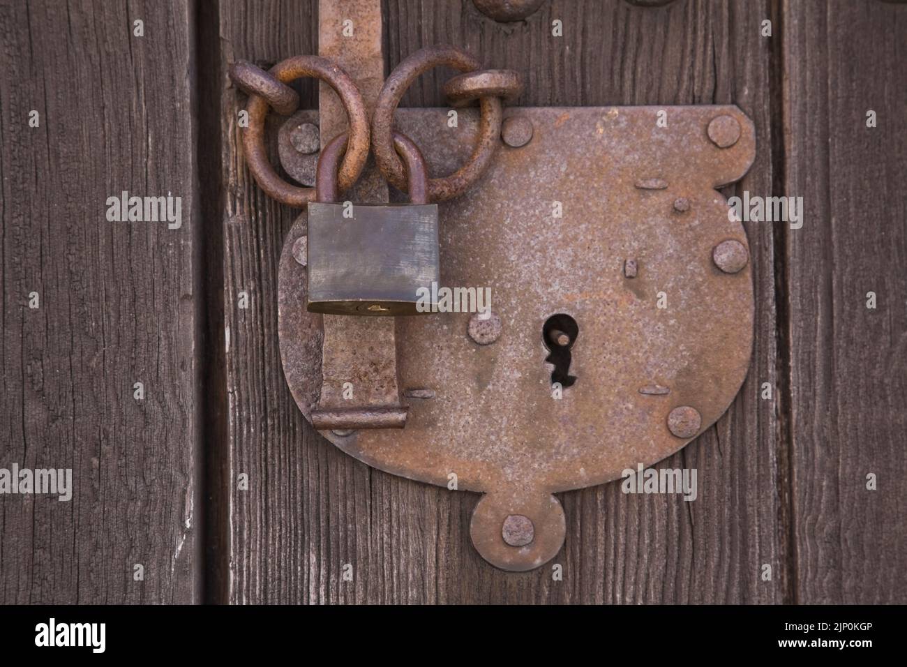 Close-up of lock and keyhole on old wooden door inside the walls of the ...