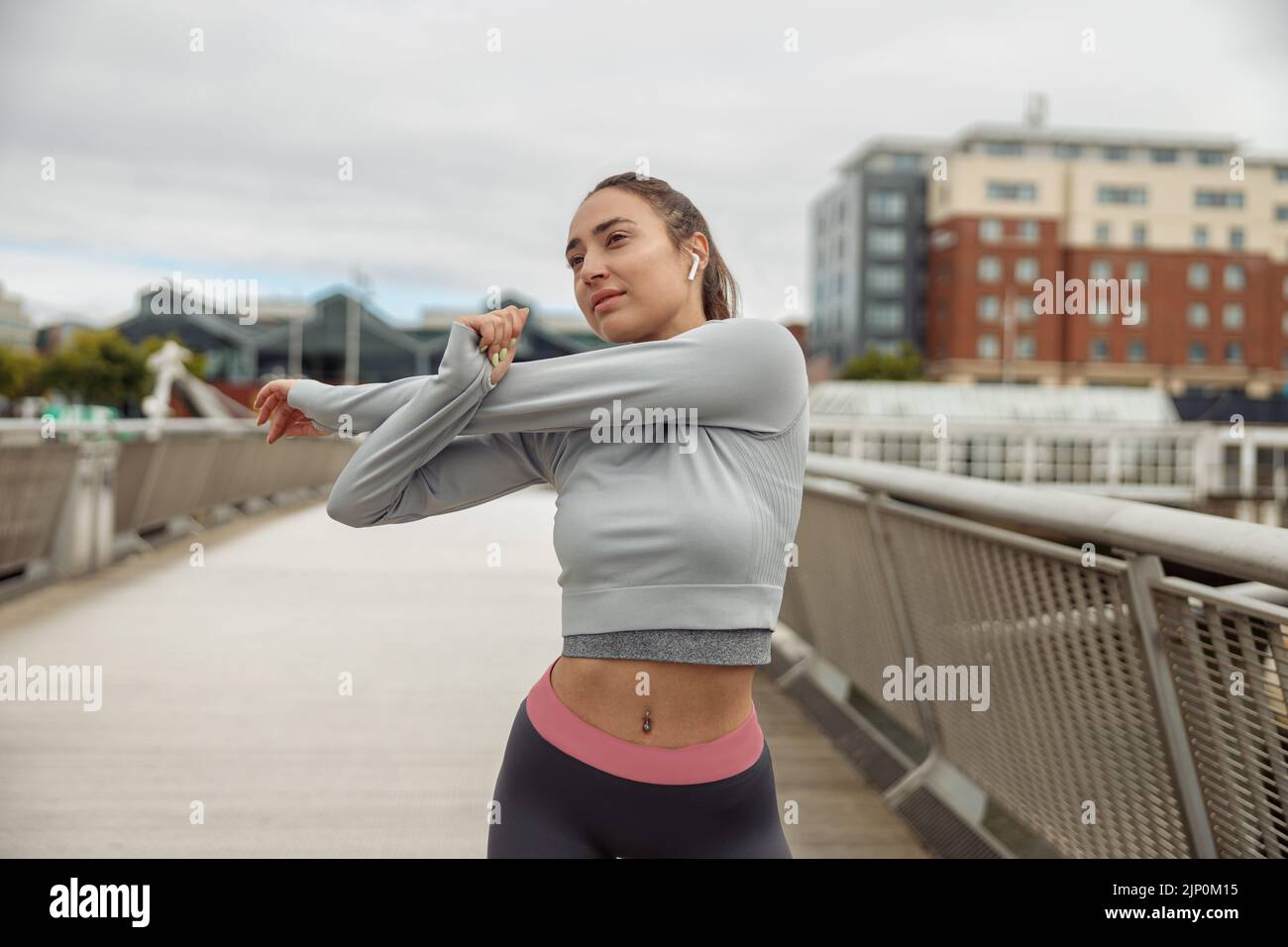 Beautiful sportive woman doing stretching exercise on footbridge in the ...