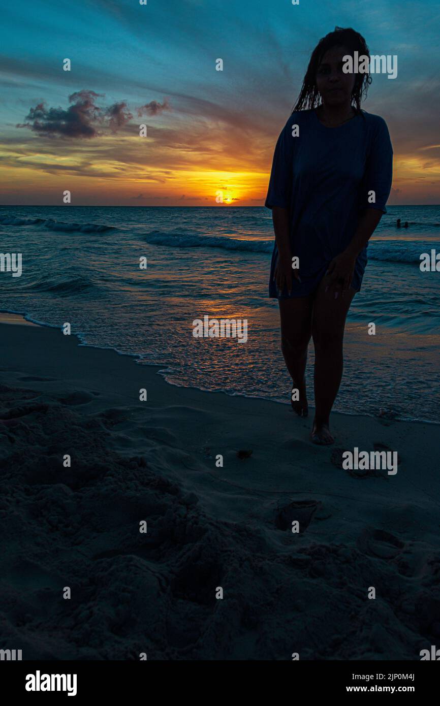 A 22 year old, Cuban female walks towards the beach after a nice swim ...
