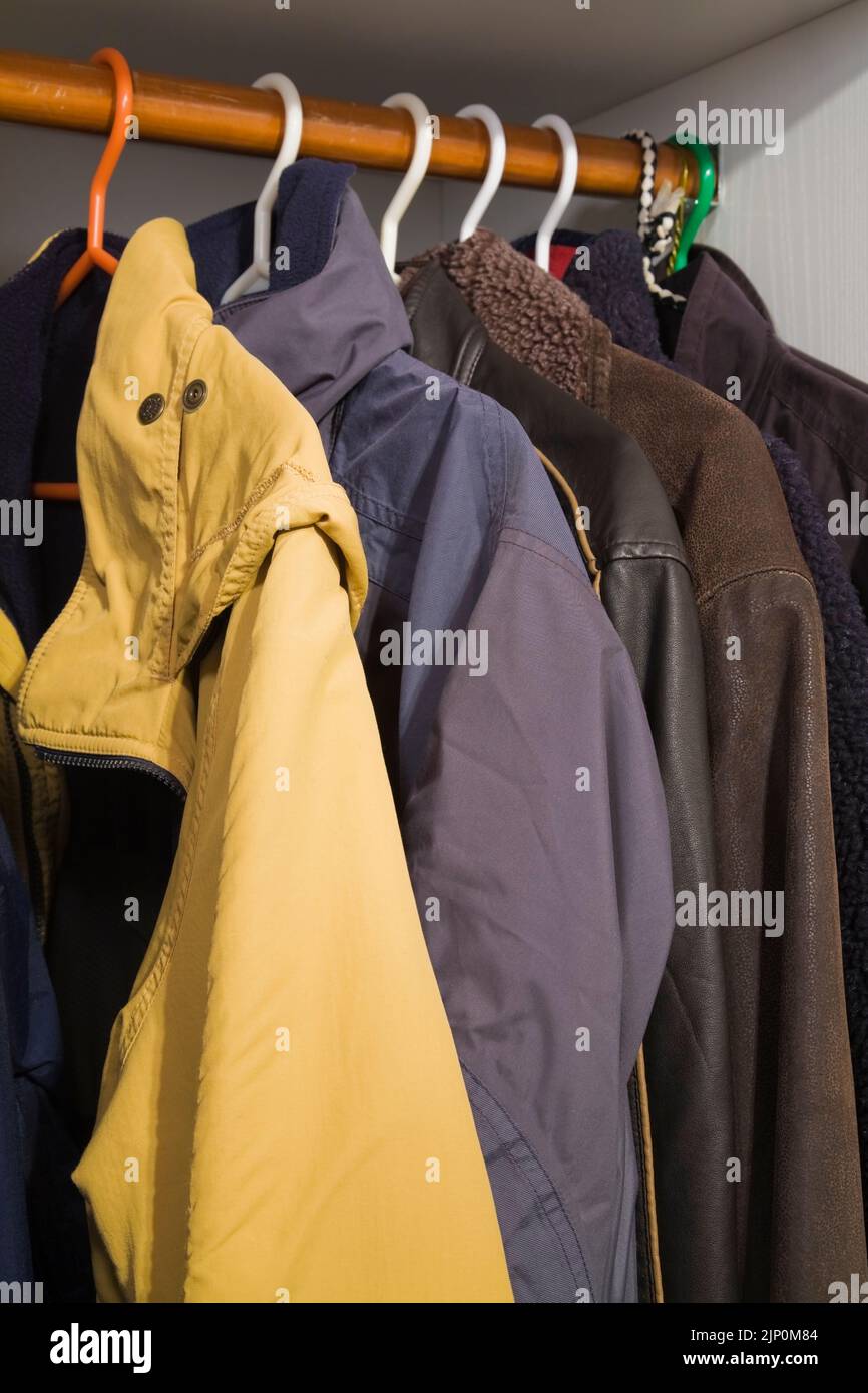 Winter jackets on hangers in a storage closet Stock Photo - Alamy