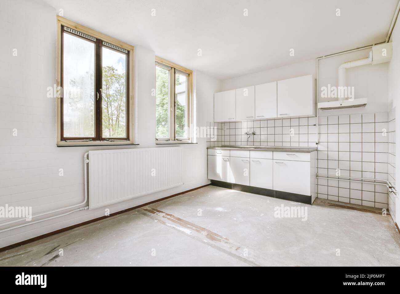 Interior of empty white kitchen with windows and wooden parquet floor ...