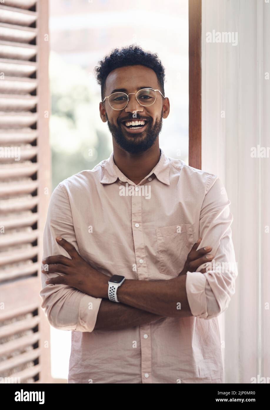Happy, carefree and positive young business man standing arms crossed ...