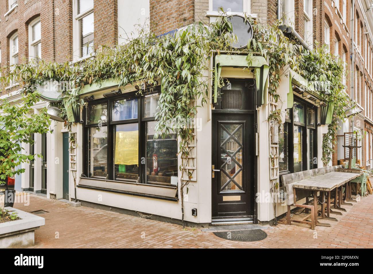 The front view of a brick building with signs, pavement and wooden ...