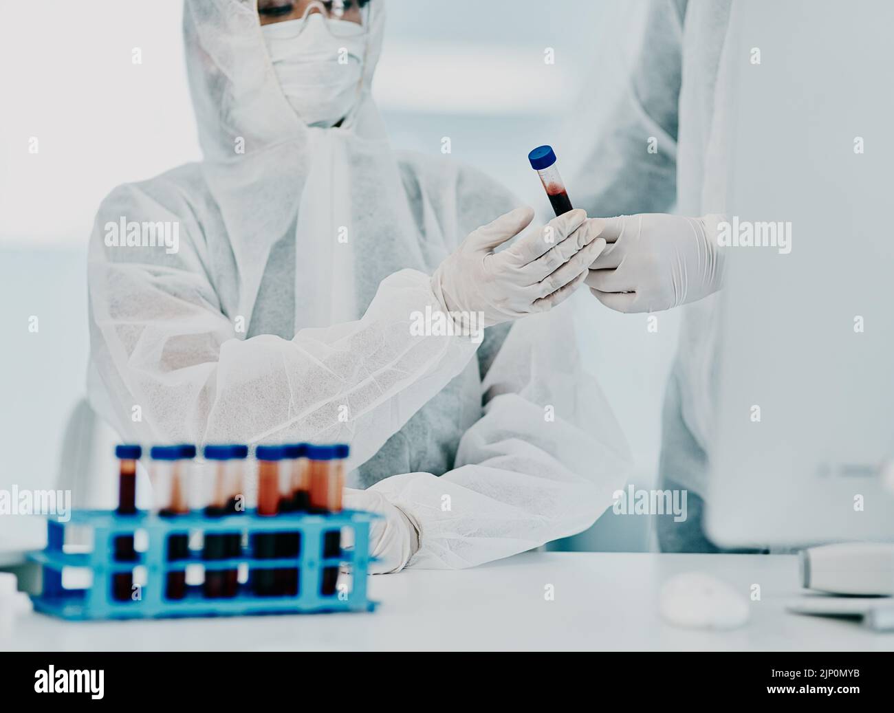 Scientists testing covid blood sample with protective ppe to prevent ...