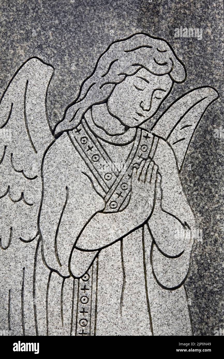 Religious winged angel in prayer figure depicted on grey granite ...