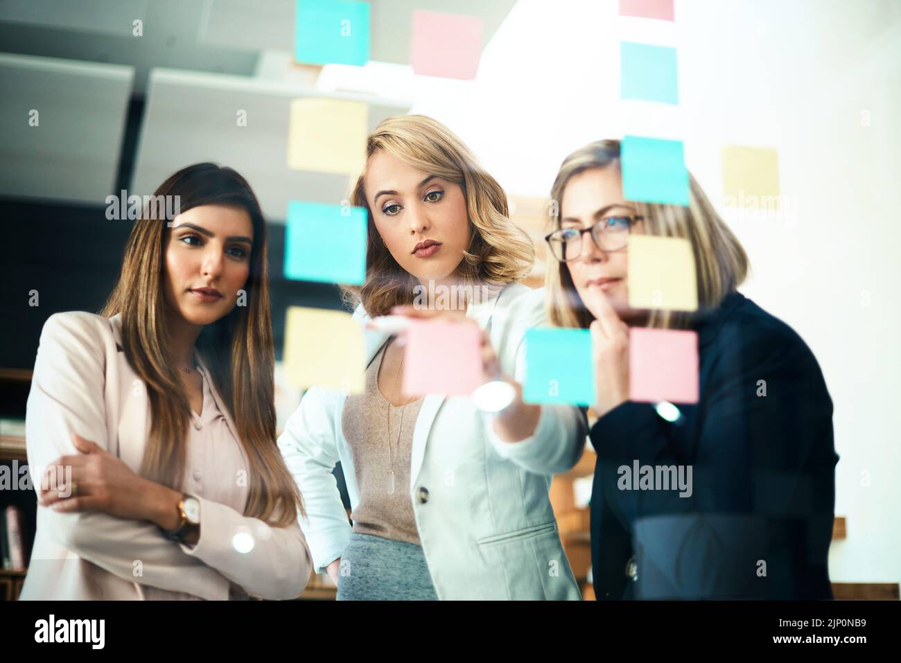 Talking team leader writing on sticky notes while planning, innovating ...