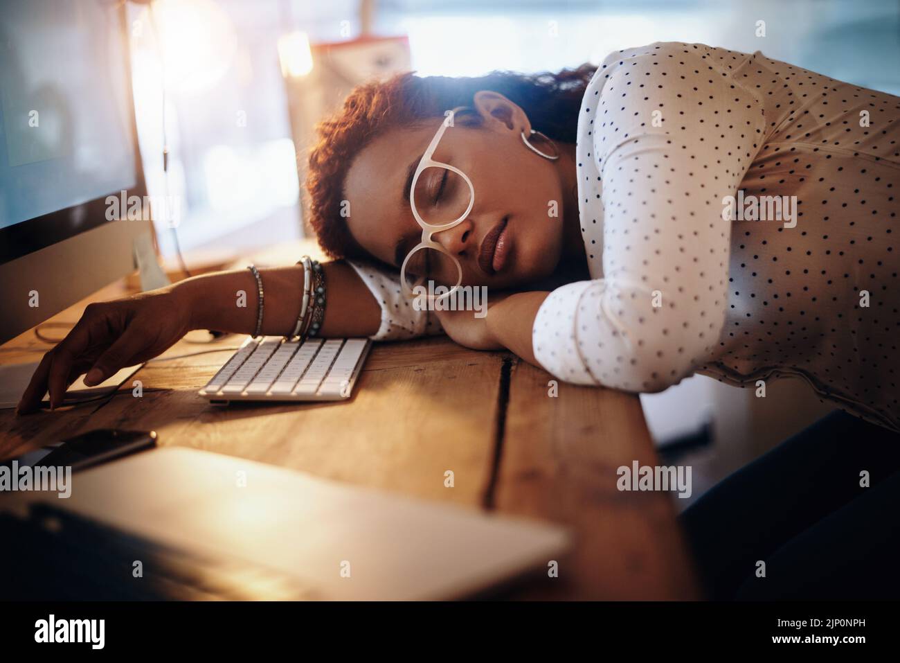 I could use a power nap... a young businesswoman sleeping at her desk ...