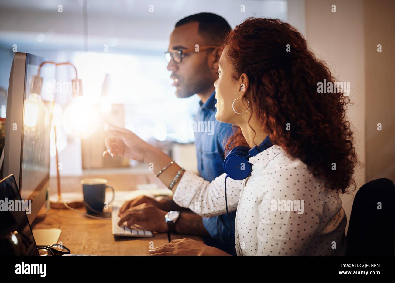 Staying the night to get the job done. two businesspeople working ...