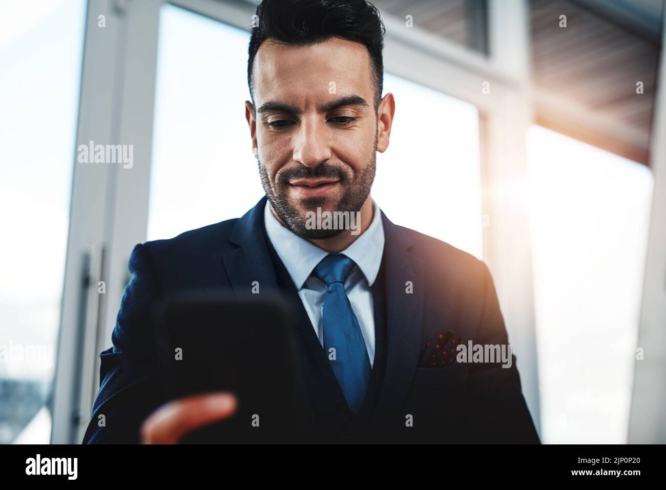 Cellphones are improving the corporate world. a handsome male executive ...