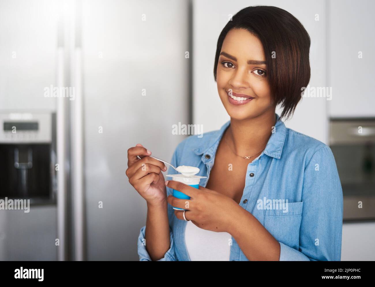 My healthy mid morning snack. an attractive young woman eating a tub of ...