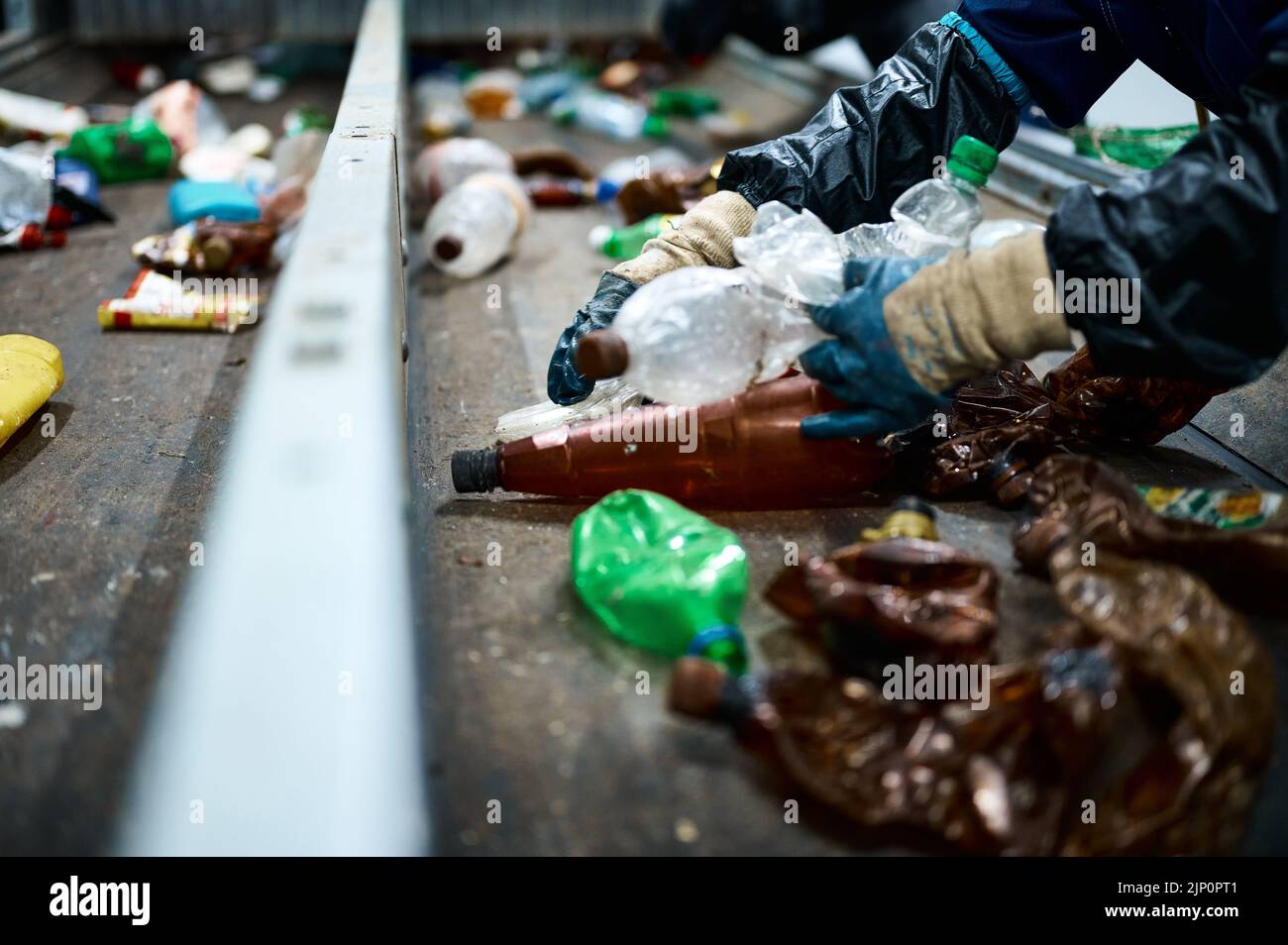 Worker sorts trash on conveyor belt at waste recycling plant Stock Photo - Alamy