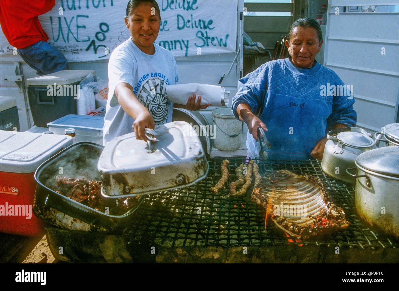 Native American Navajo women preparing a meal of grilled meat, Tuba ...