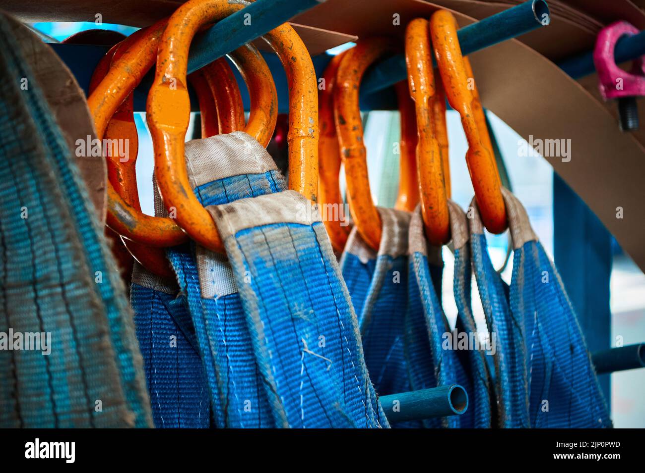 Rigging equipment with textile strops hangs on rack hooks Stock Photo ...