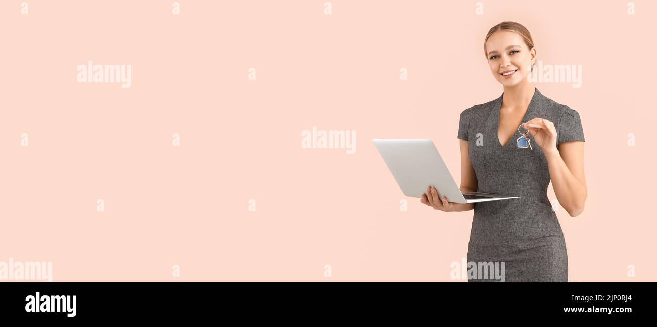 Female real estate agent with laptop and key on pink background with ...