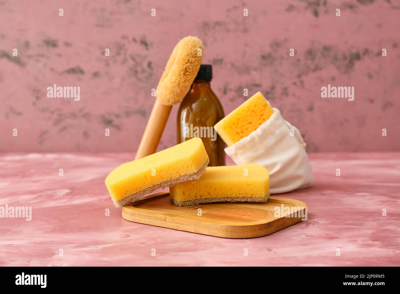 Different cleaning supplies, wooden board and bottle on color ...