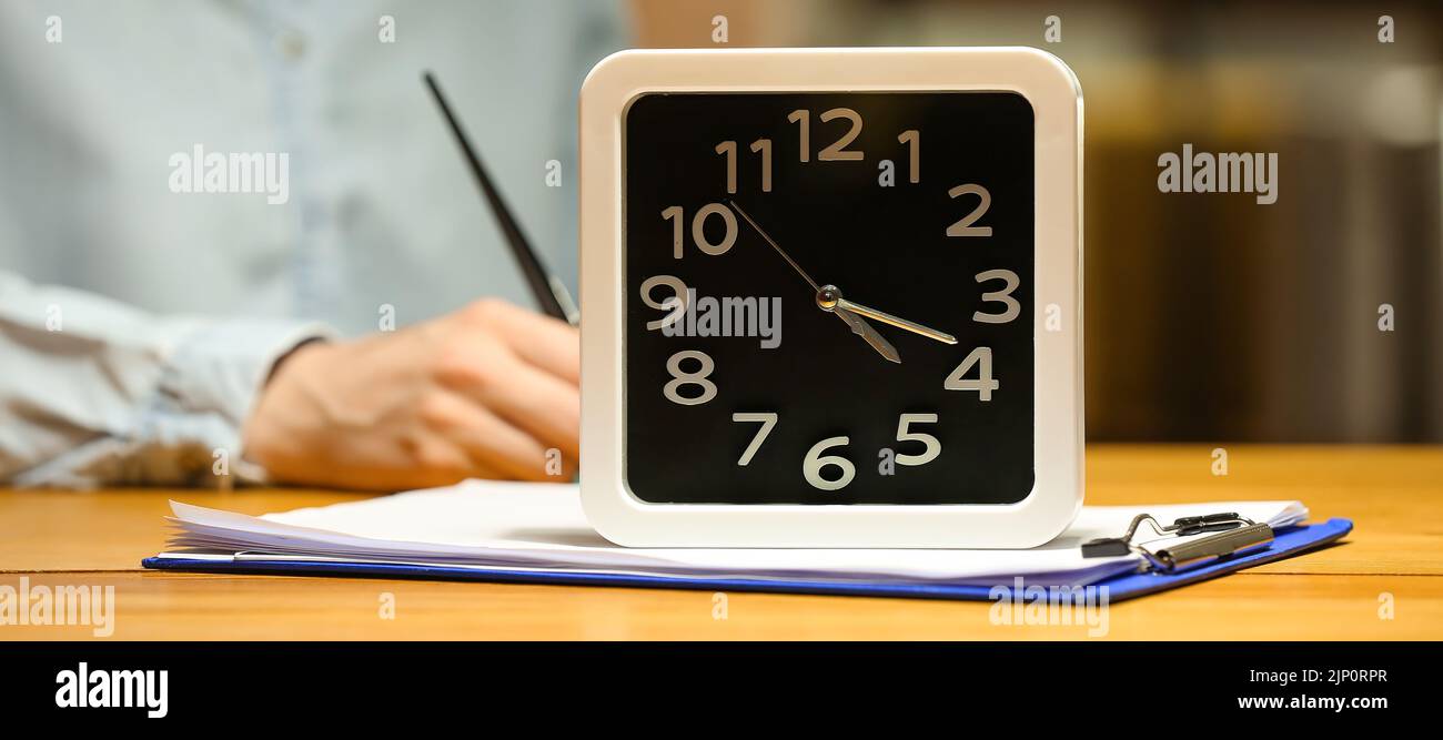 Clock with document on table in office. Time management concept Stock ...