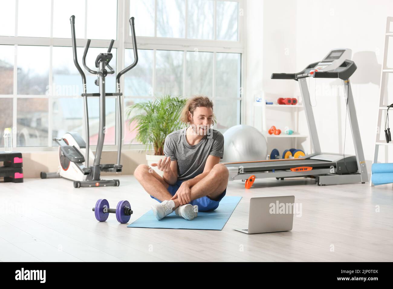Sporty young man with laptop training in gym Stock Photo - Alamy