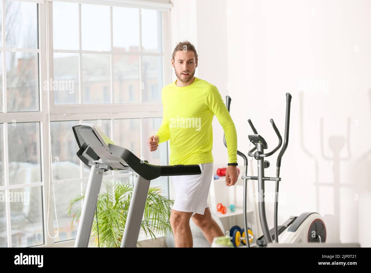Sporty young man using step machine in gym Stock Photo - Alamy