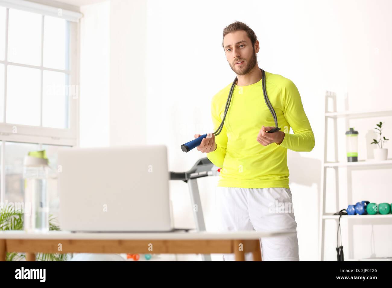 Sporty young man using laptop for online training in gym Stock Photo ...