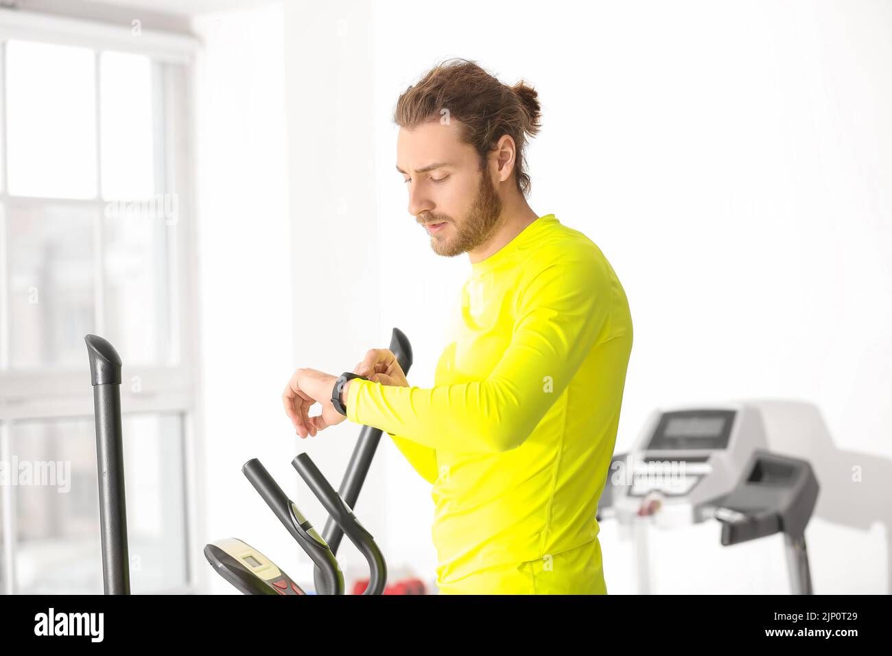 Sporty young man with fitness tracker training in gym Stock Photo - Alamy