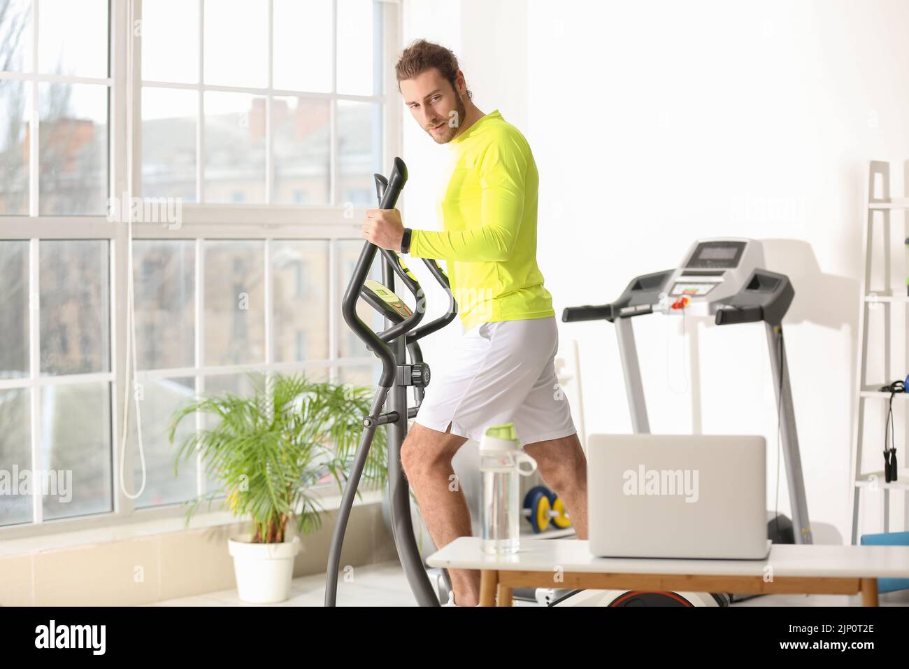 Sporty young man using laptop for online training in gym Stock Photo ...