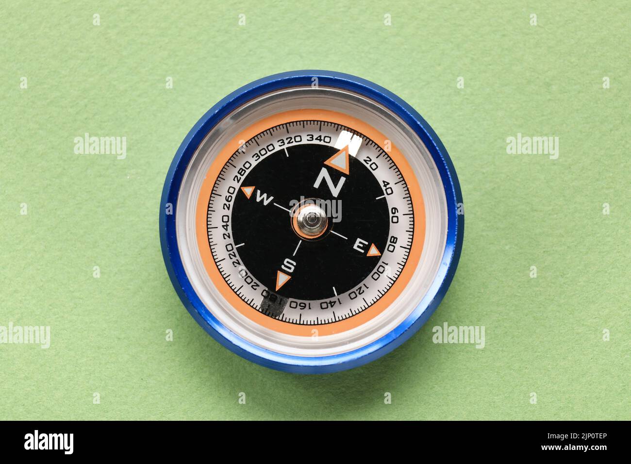Tourist's compass on green background Stock Photo - Alamy