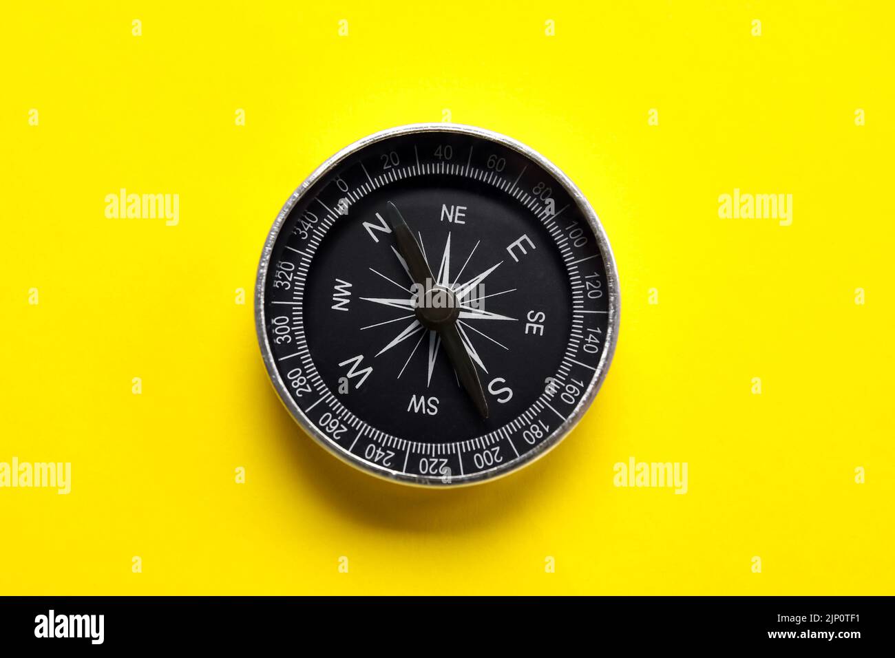 Tourist's compass on yellow background Stock Photo - Alamy