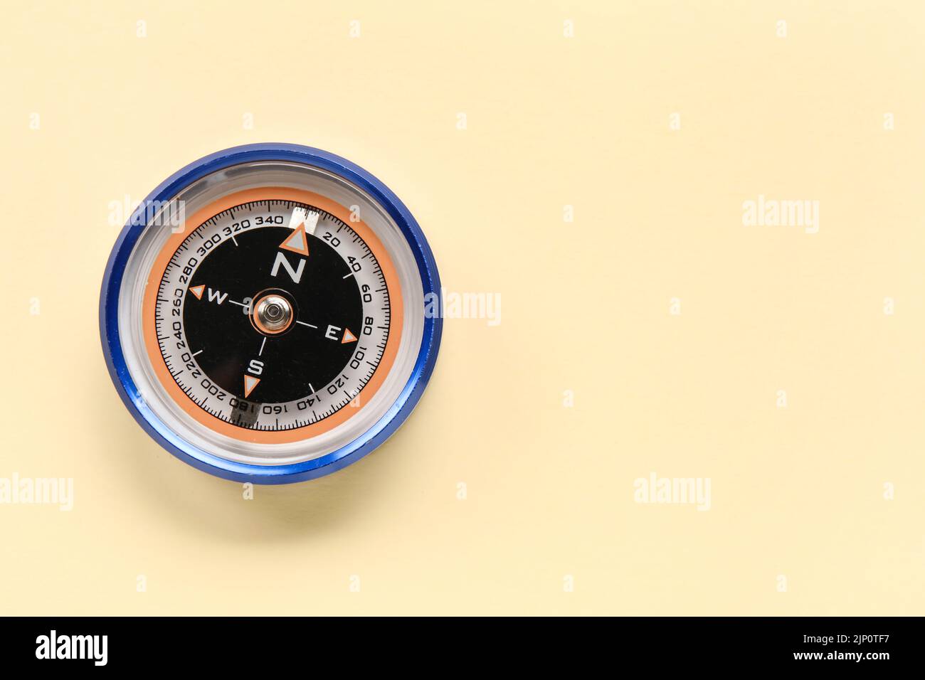 Tourist's compass on beige background Stock Photo - Alamy