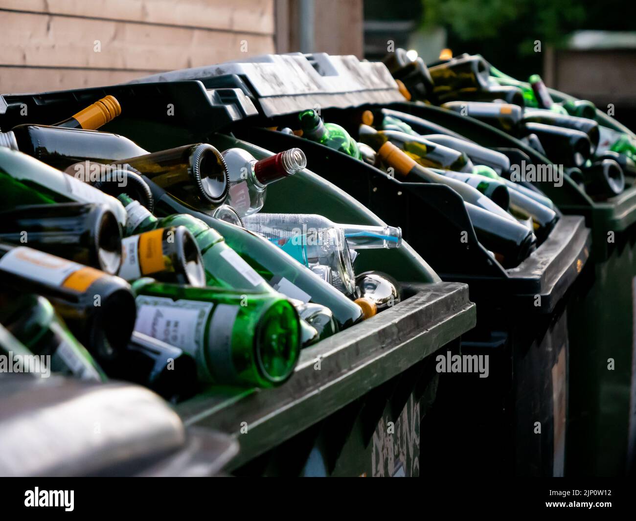 Lots of empty glass bottles in different colors are disposed in huge ...