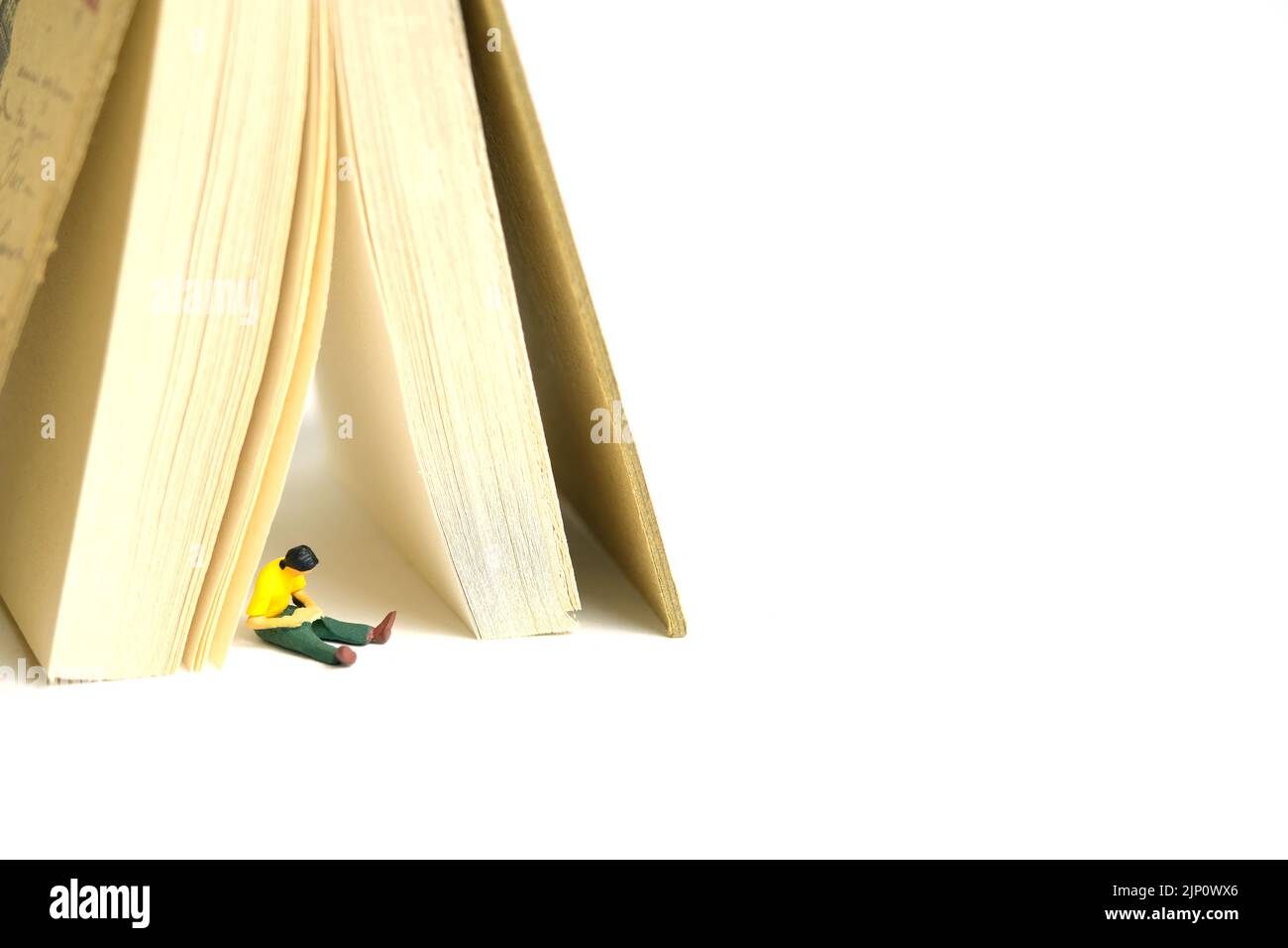 Miniature people toy figure photography. A men student sitting under ...