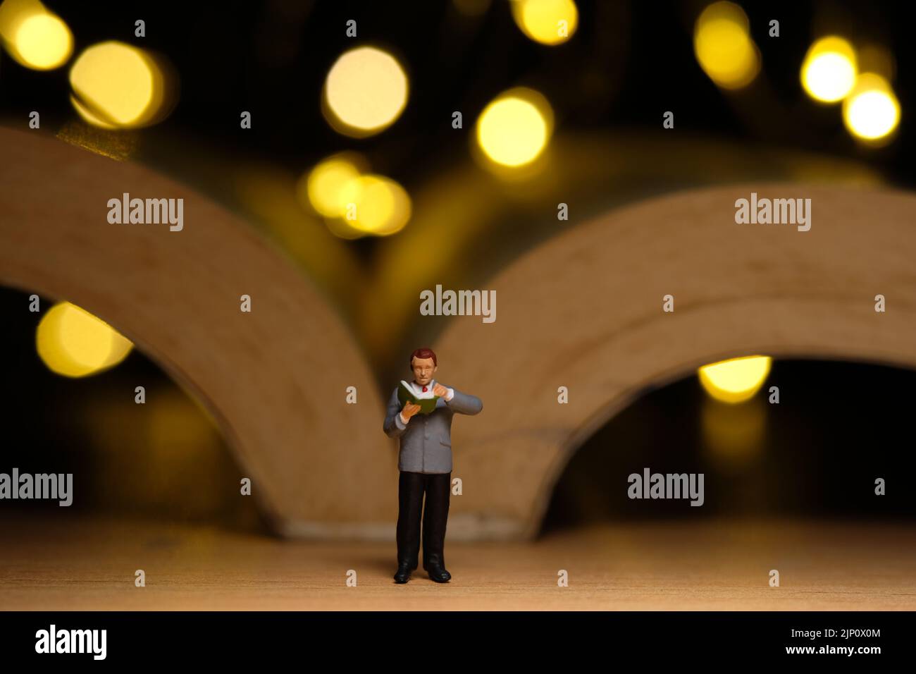 Miniature people toy figure photography. A boy reading a book at night ...