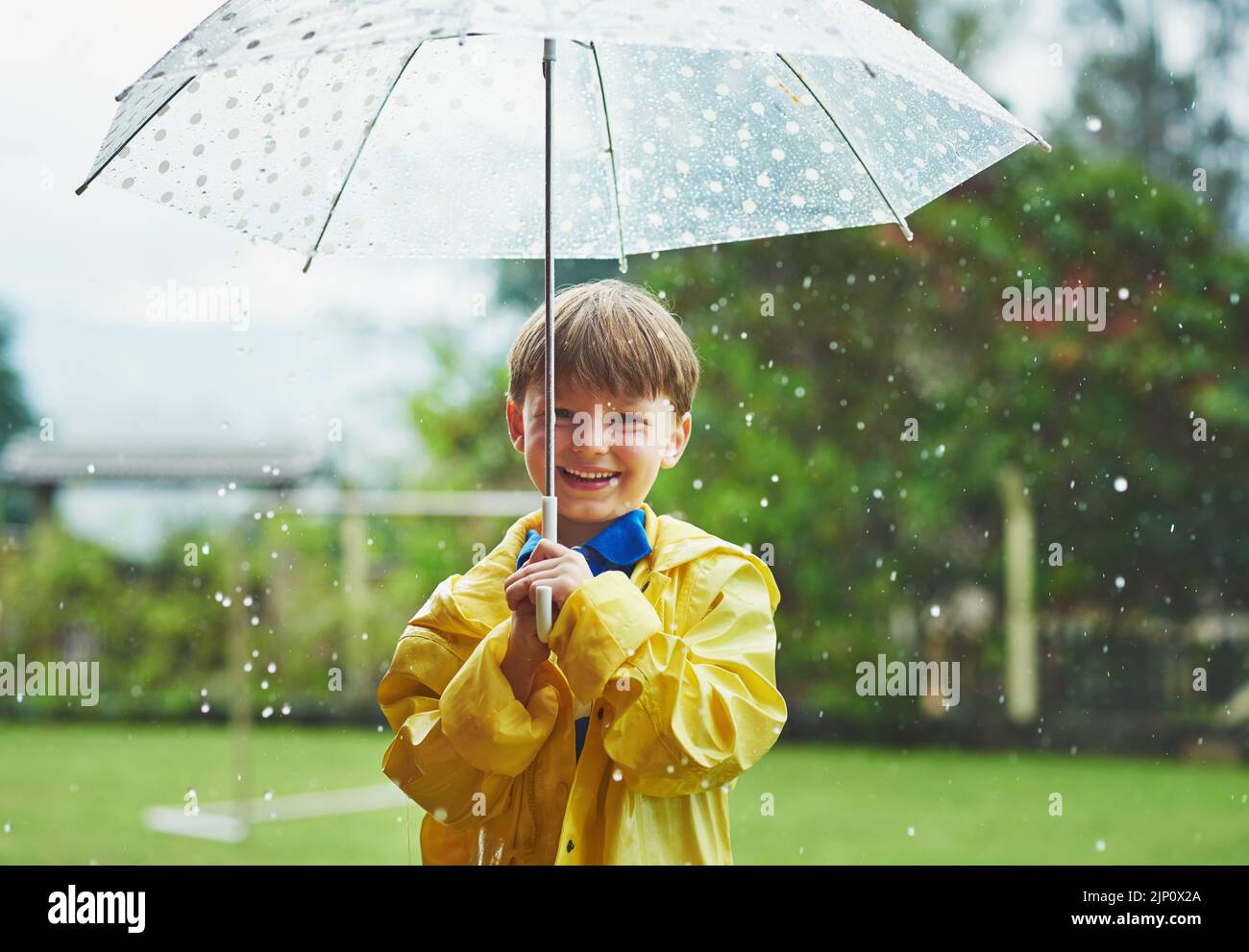 Rain never stops him from going outside. Portrait of a cheerful little ...