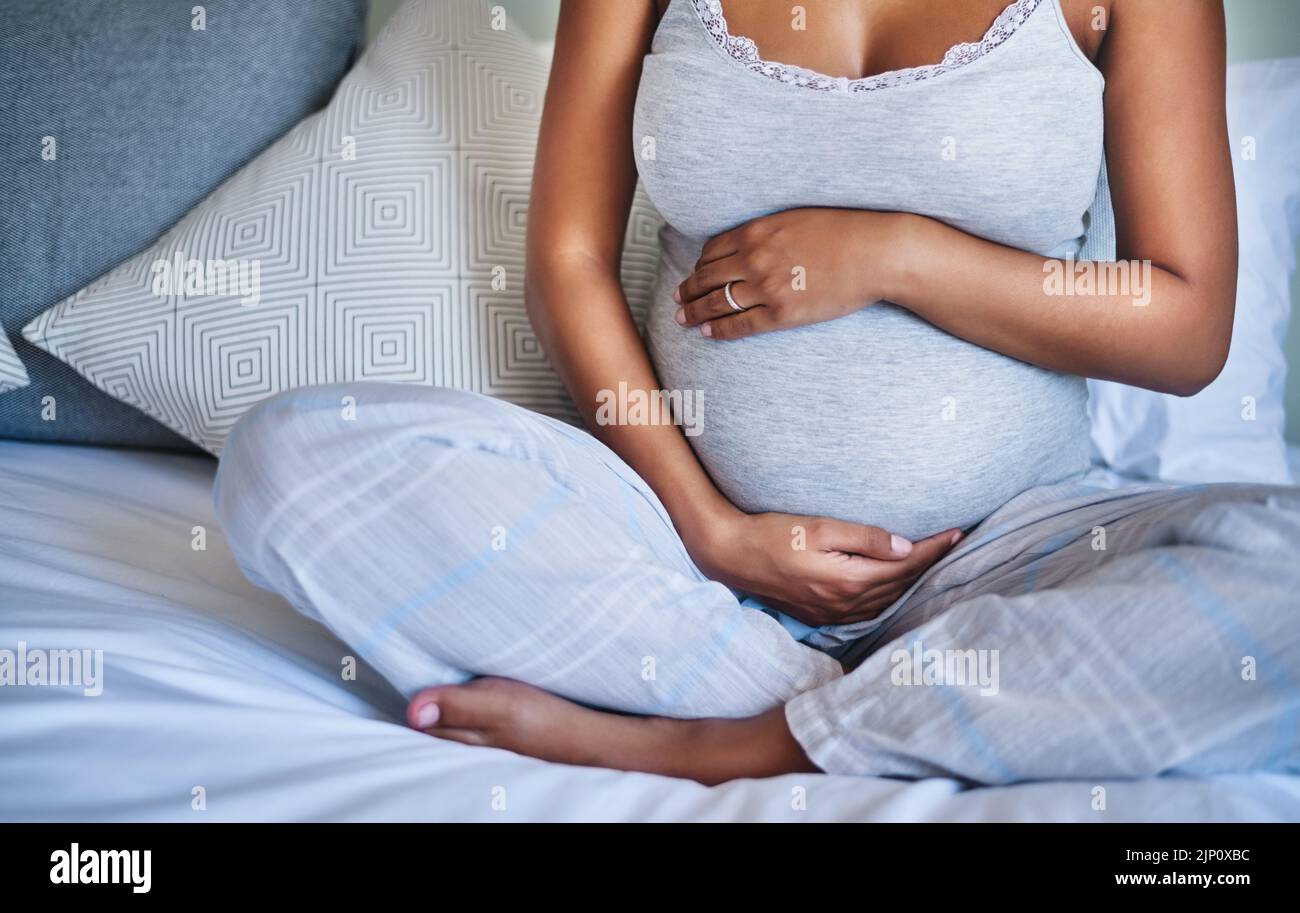 Love starts in the womb. a pregnant young woman relaxing on the bed at ...