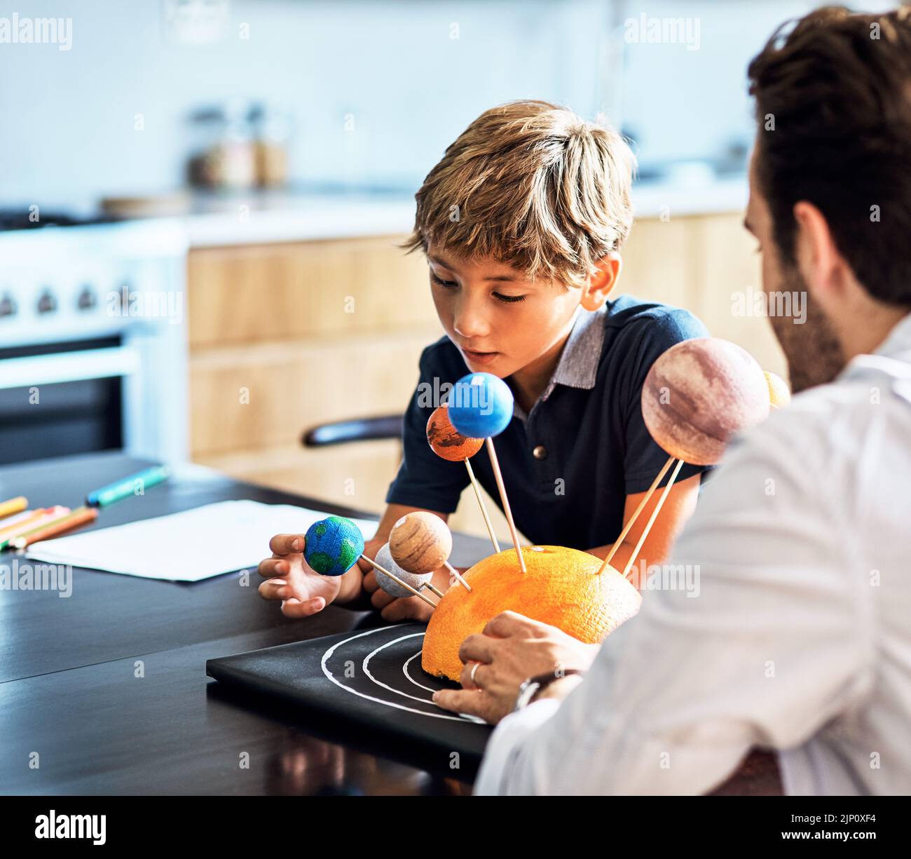 Encourage young minds to stay curious. a father helping his little son ...