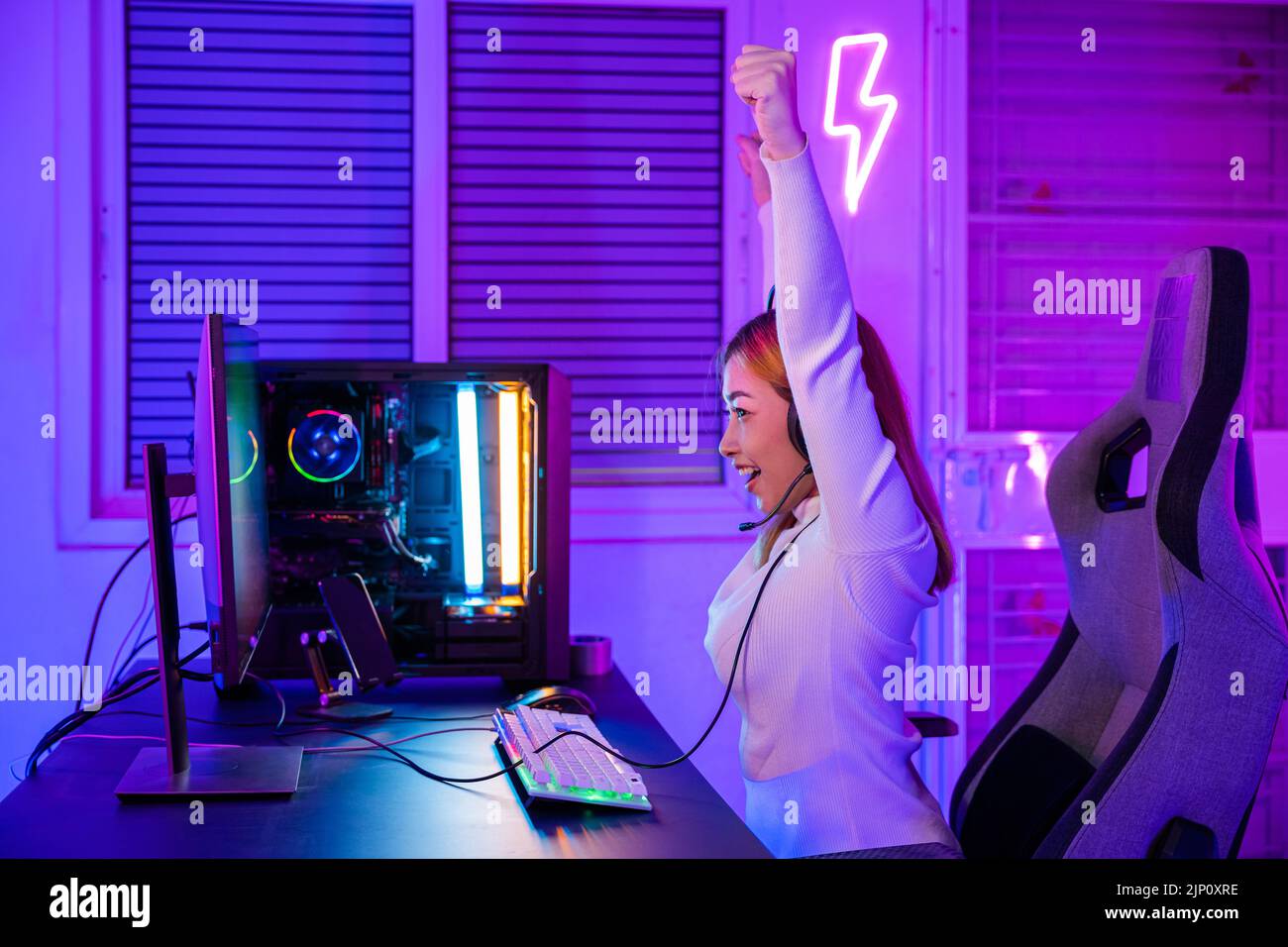 Winning Victory. Asian gamer playing online video game excited on ...