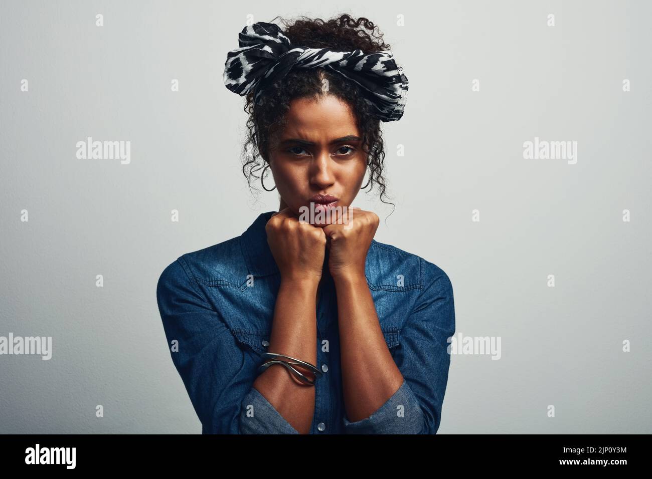 She may be cute until you mess with her. Studio shot of an attractive ...