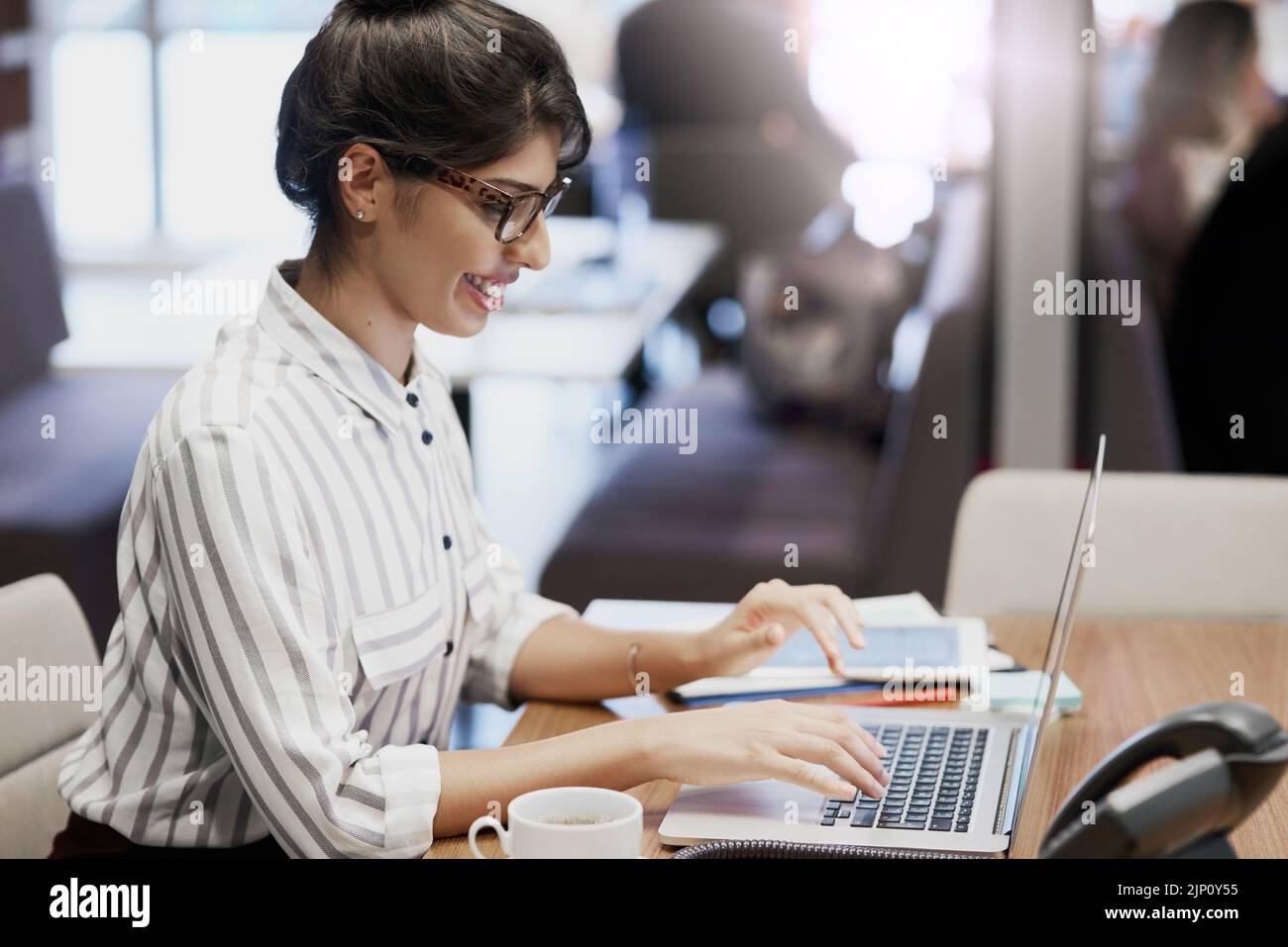 Woman smiling as she works on laptop hi-res stock photography and ...