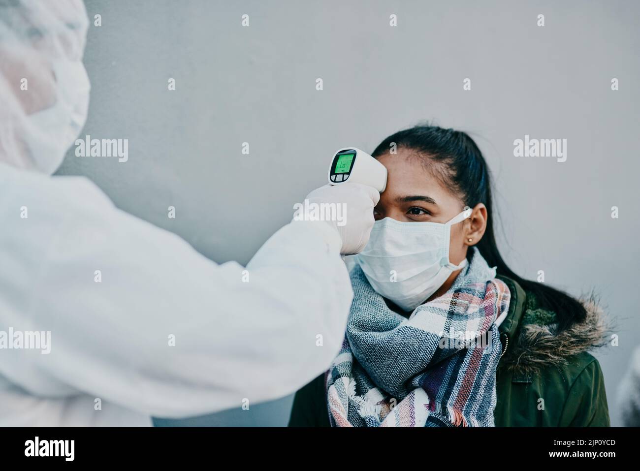 Healthcare doctor scanning the temperature of a patient for corona with ...