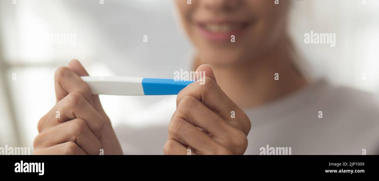 Happiness young asian woman taking pregnancy test while excited and ...