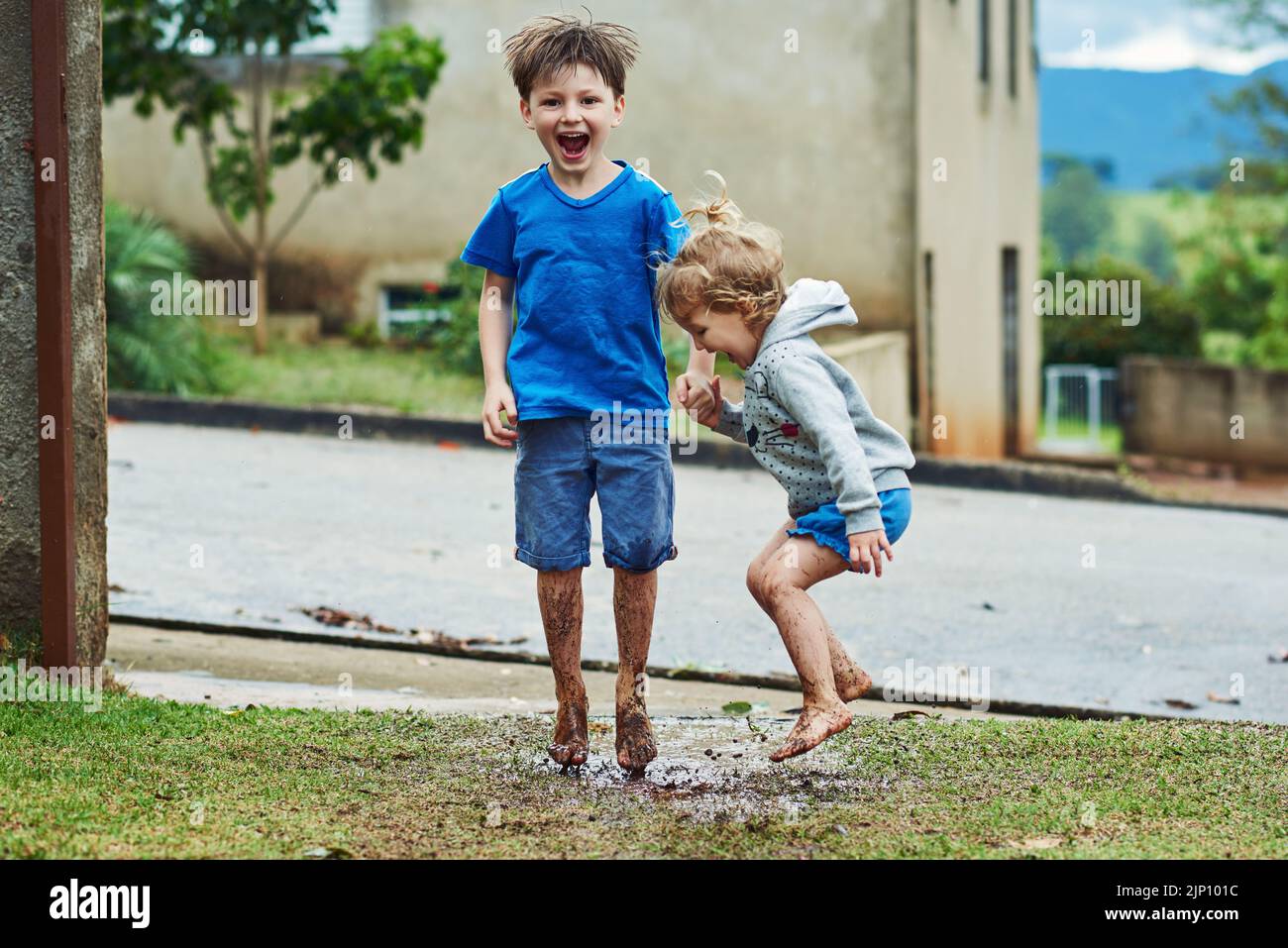 When its pouring outside its time to go play. Portrait of two cheerful ...
