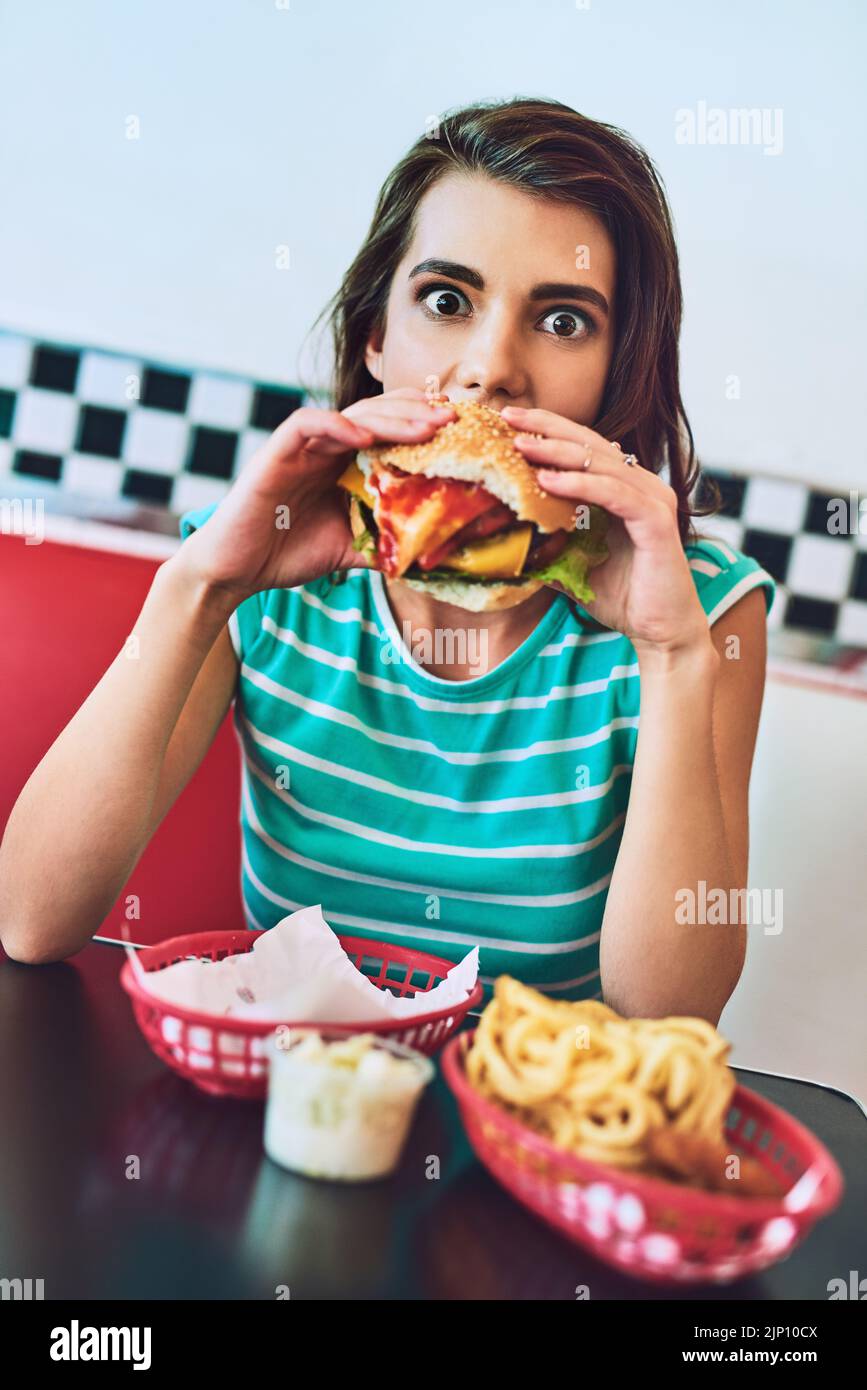 This burger is perfect. Cropped portrait of an attractive young woman ...