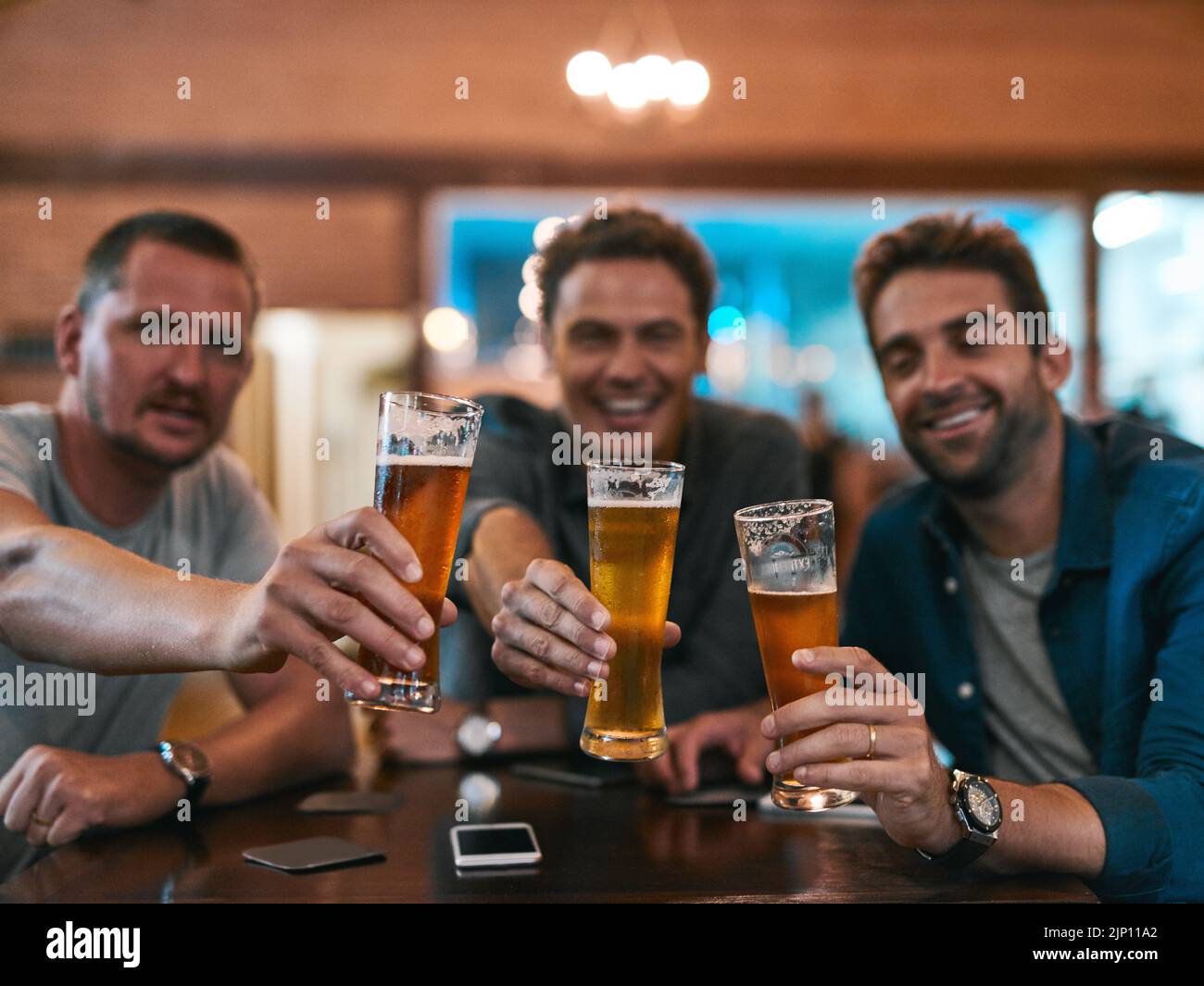 We make the best beer in town. Portrait of three cheerful young men ...