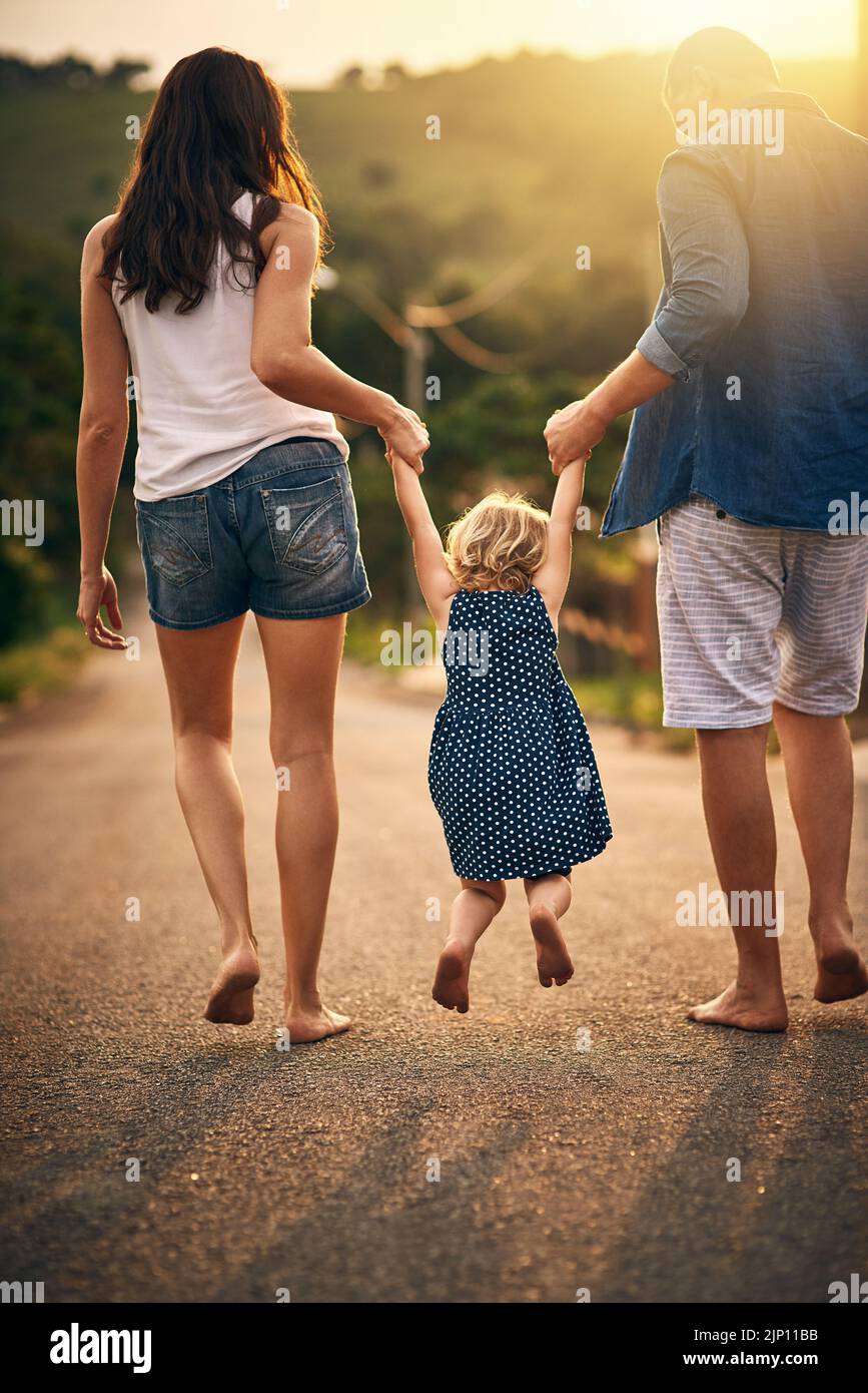 Getting some fresh air by taking a walk outside. Rearview shot of an ...