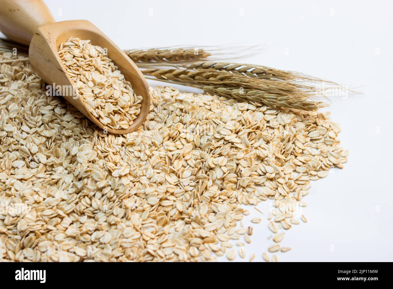 rolled oat meals uncooked with wooden scope in white background Stock ...
