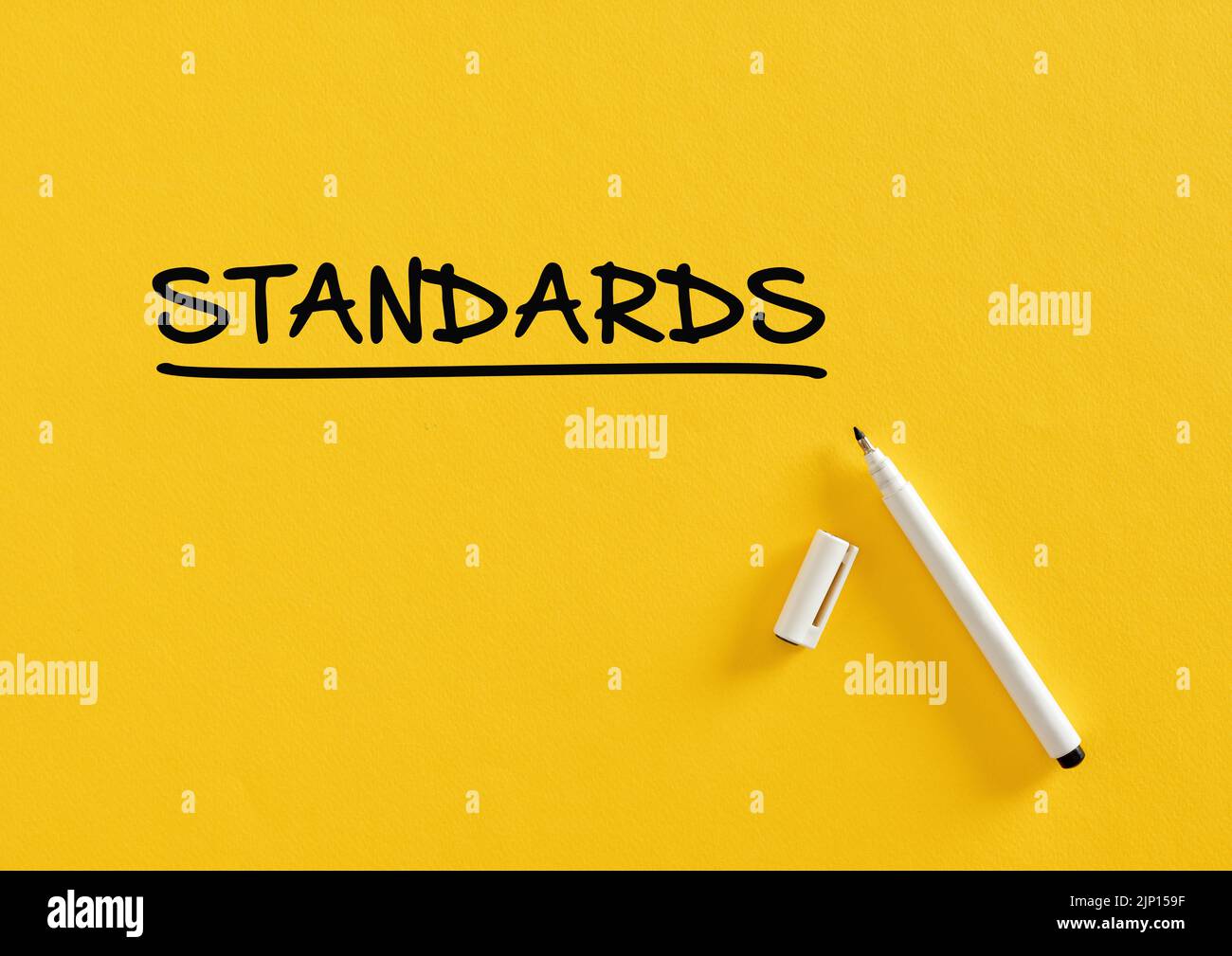 The word standards written on yellow background with felt tip pen ...