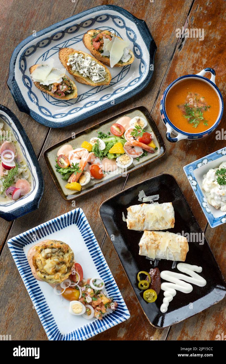 selection of many different mixed tapas on rustic wood table in ...