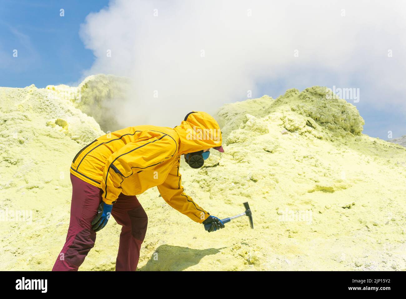 female volcanologist on the slope of a volcano next to a smoking ...