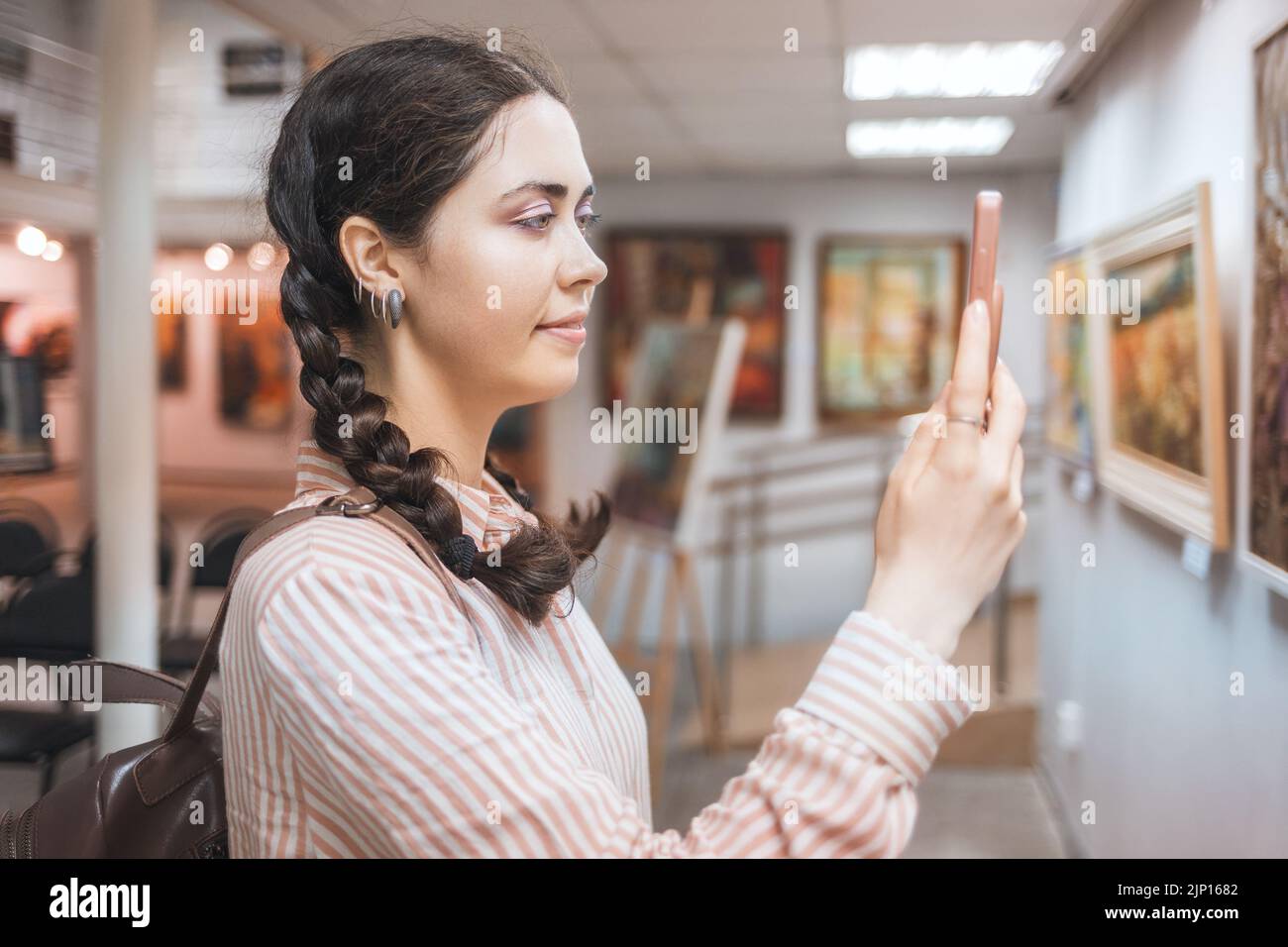 Portrait of smiling caucasian woman using a smartphone. Virtual excursion with audio guide in ...