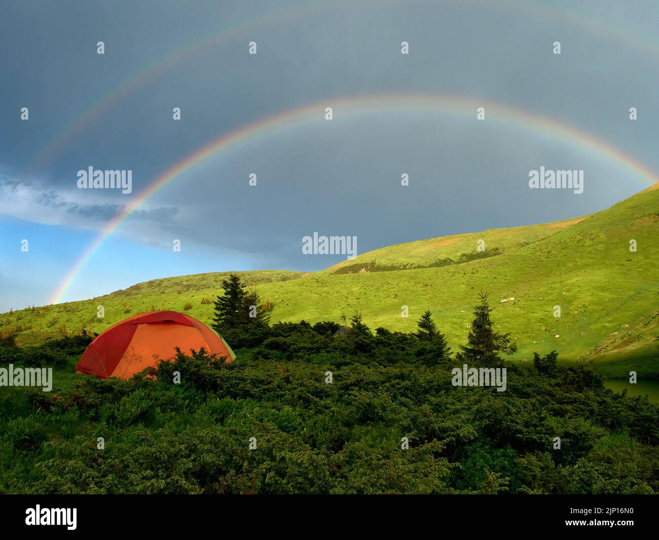 A tourist tent in the mountains on the background of a rainbow Stock ...